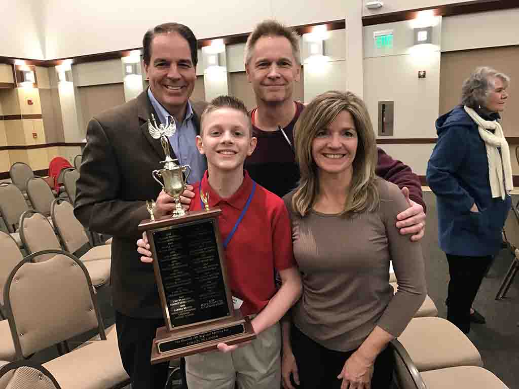 Rick standing next to a couple and their son. The son is holding a ...